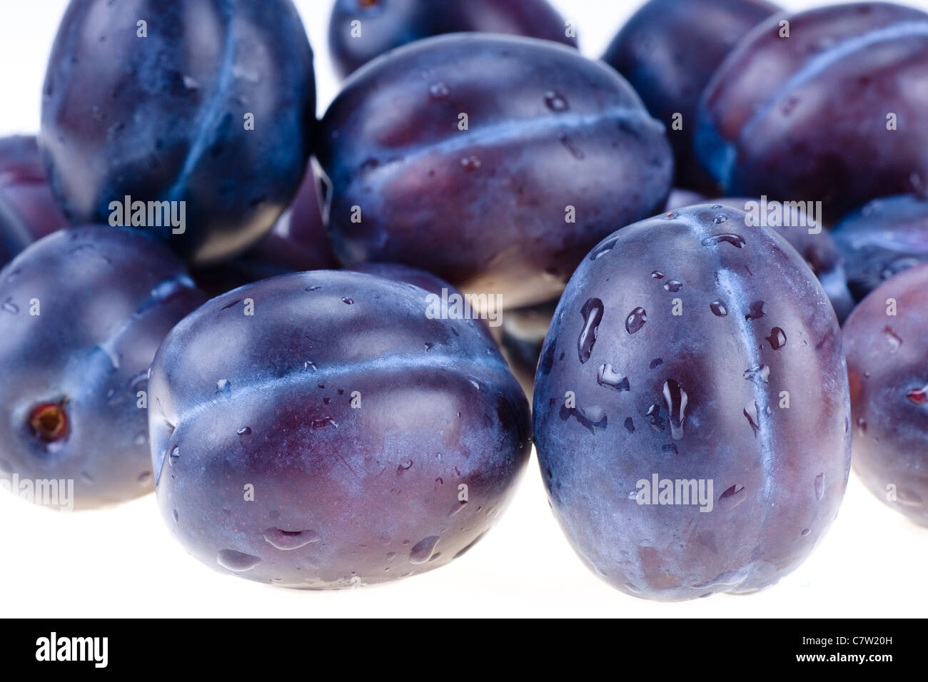 Stack of blue plums isolated Stock Photo - Alamy