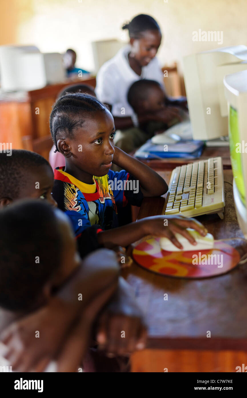 A teacher helping children during an introductory computer class ...