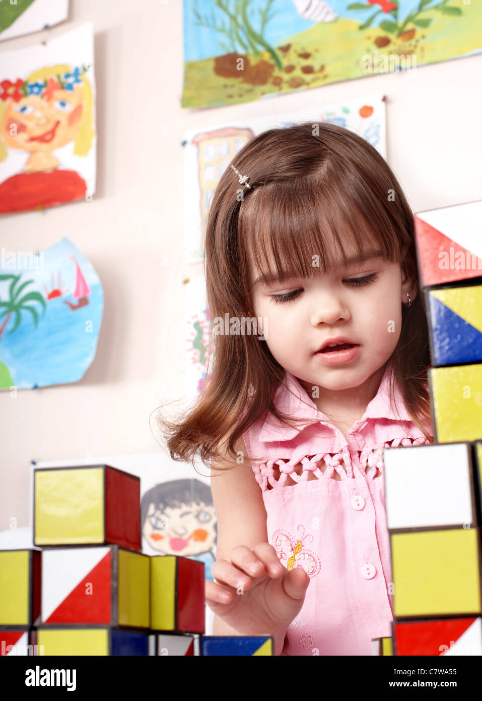 Little girl playing with wood block in room Stock Photo - Alamy