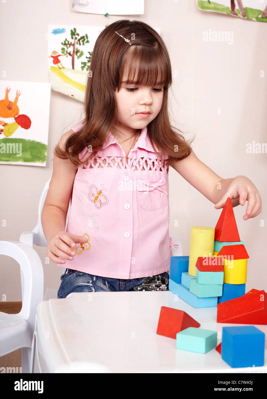 Little girl playing with wood block in room Stock Photo - Alamy