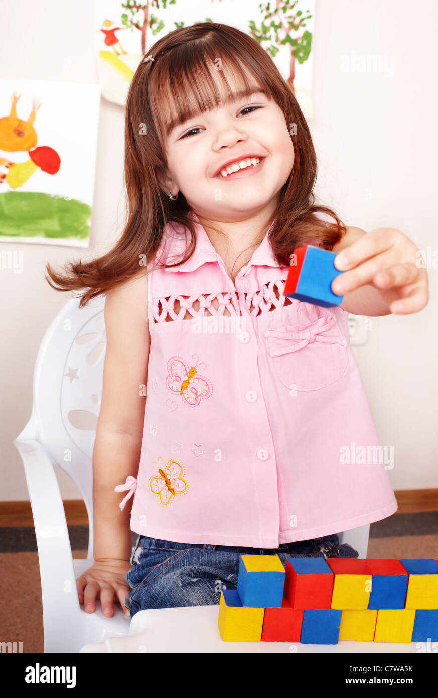 Little girl playing with wood block in room Stock Photo - Alamy