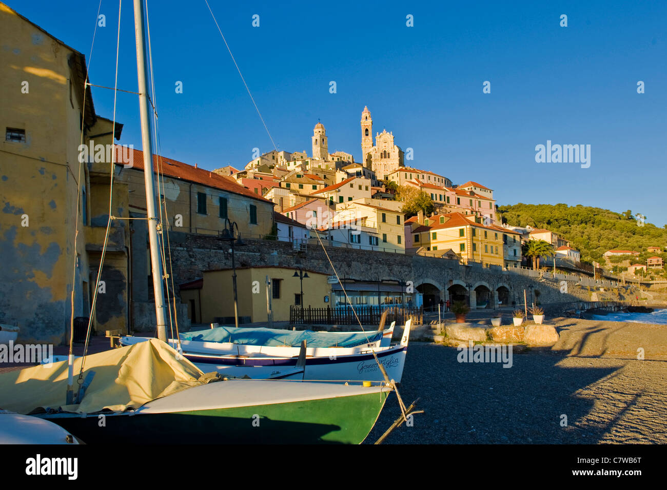 Italy, Liguria, Cervo, boat on beach and view of the village Stock ...