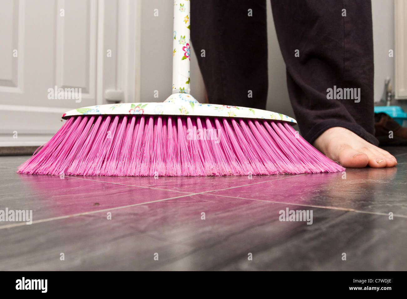 A pink broom sweeping a hard floor Stock Photo - Alamy