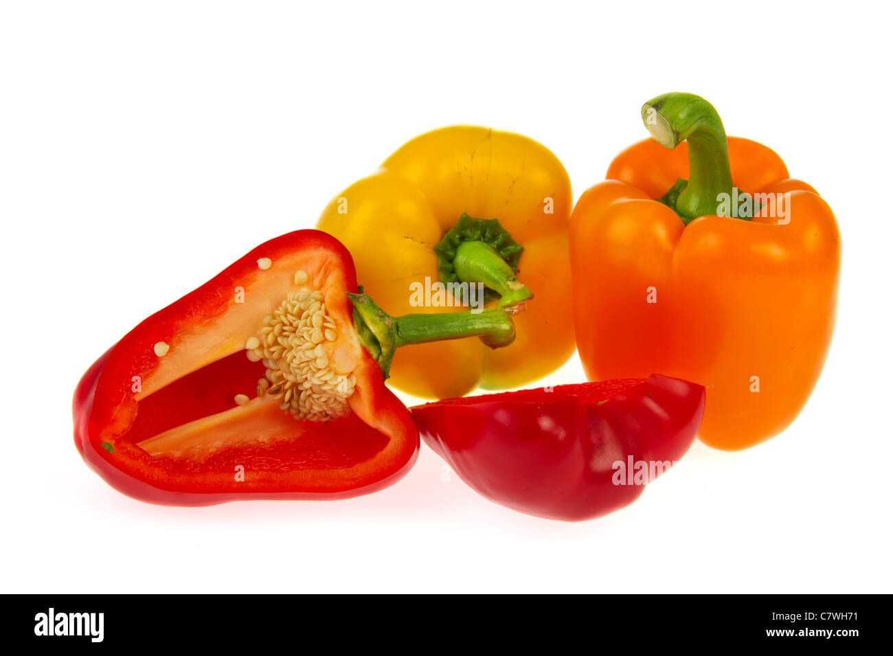Three colorful paprika with one cut isolated over white background ...
