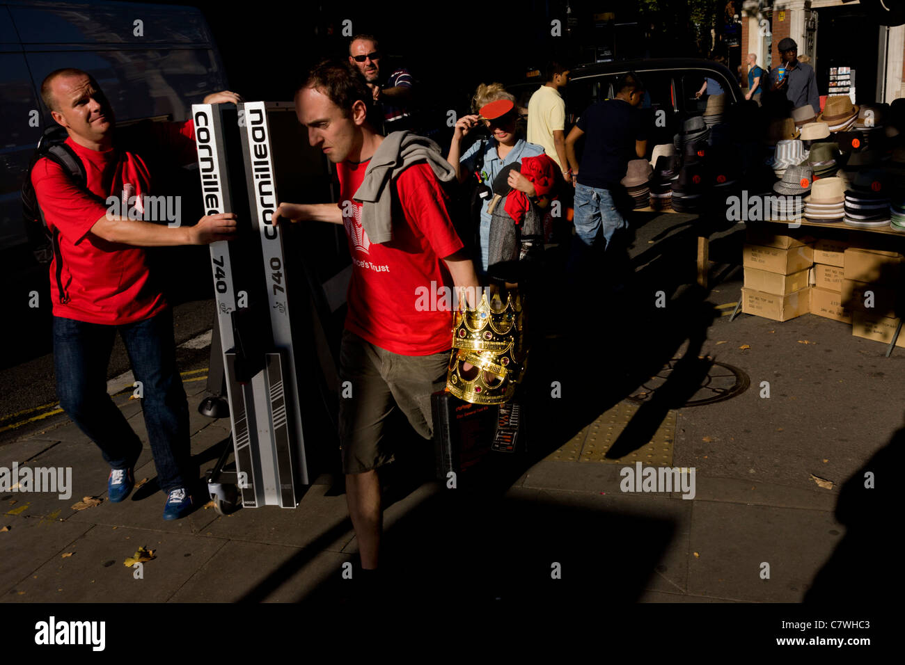 Group of friends or colleagues push a table tennis table along a west ...