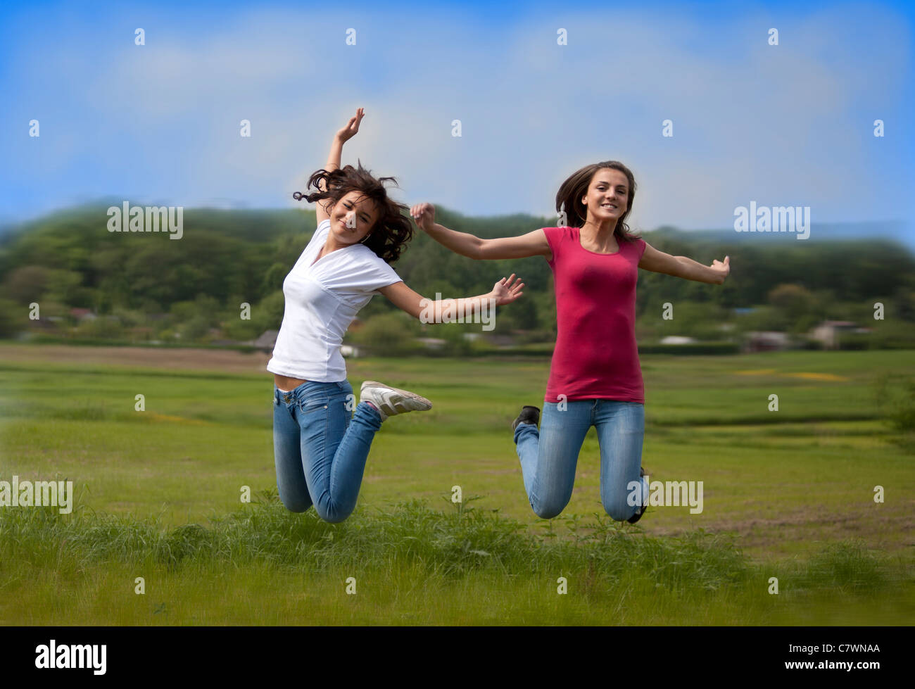 Two happy jumping girls Stock Photo - Alamy