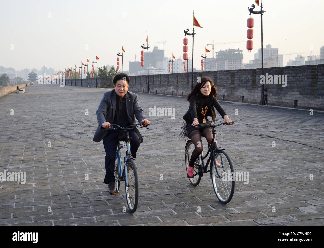 Two Chinese cyclists enjoy a ride on top of the city walls of Xi'an ...
