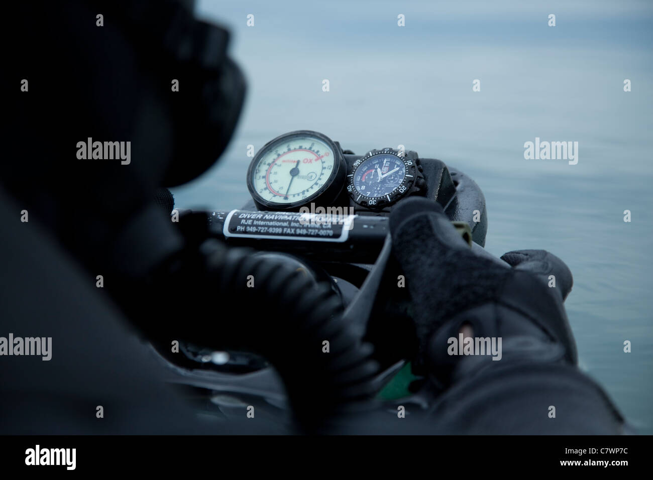 Special operations forces combat diver checks the depth gauge on his ...