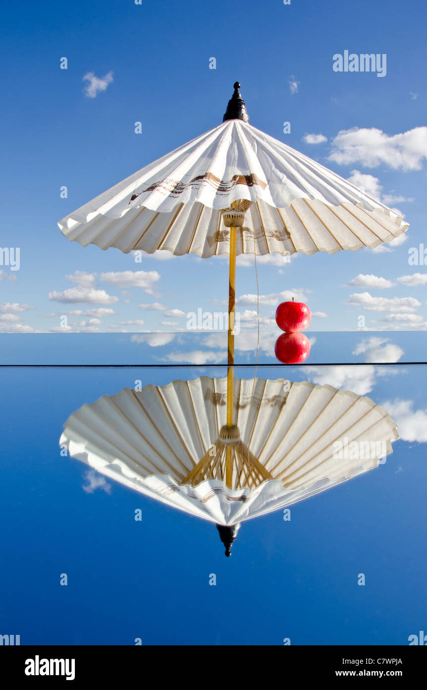 white umbrella and red apple on mirror Stock Photo - Alamy