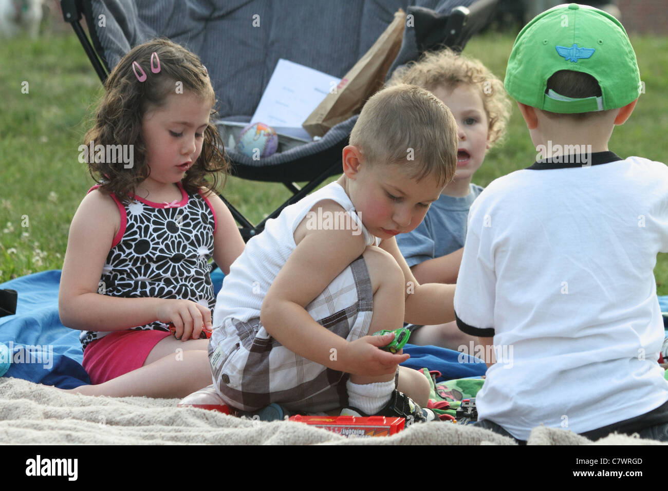 kids playing together on blanket sitting talking playing Stock Photo ...