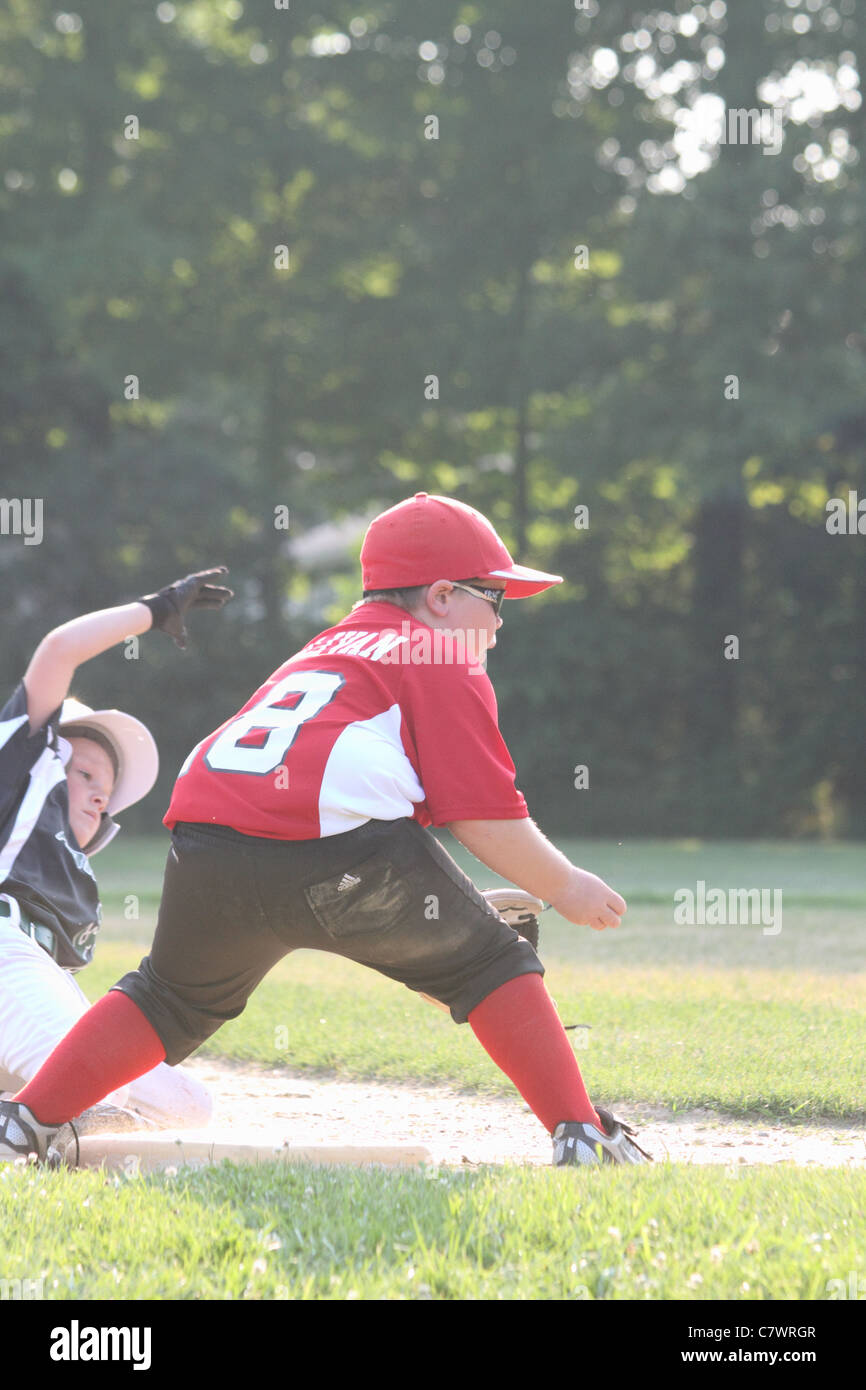 farm league baseball game save at third slide action evening Stock ...
