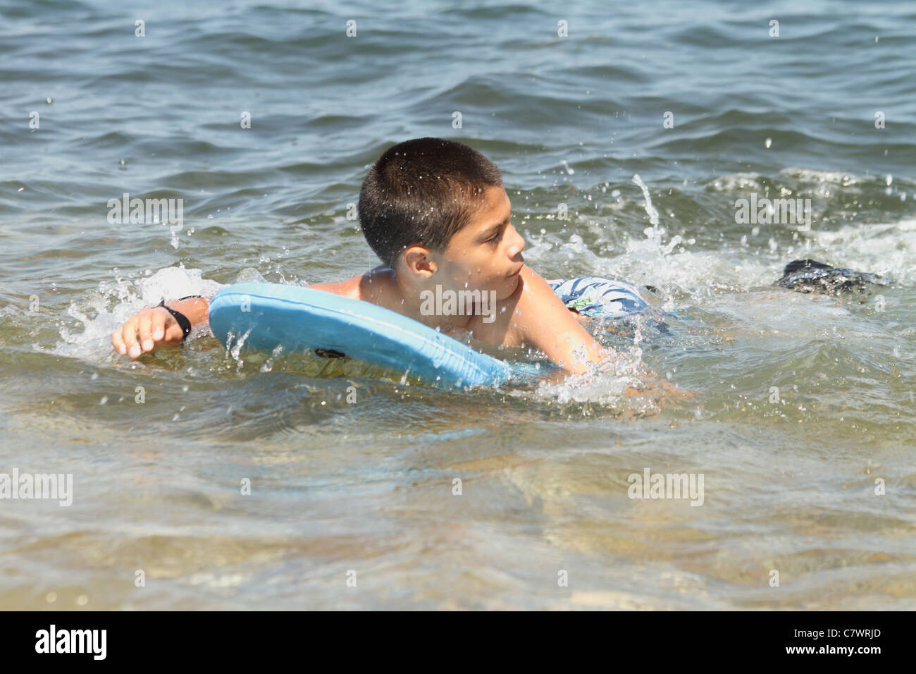riding boogie board in ocean water beach wave laying on board looking ...