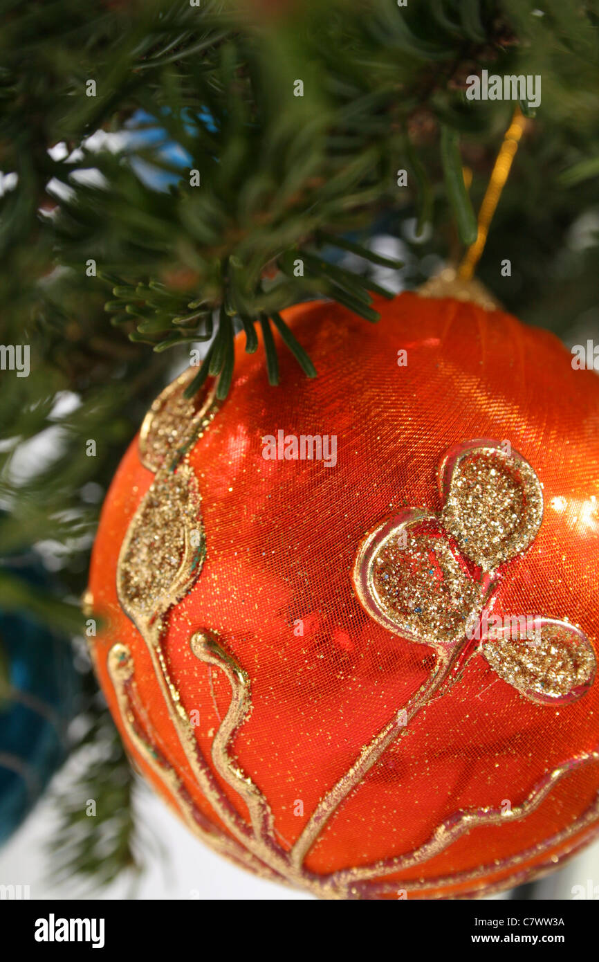 Gold Christmas ball and paper streamer hanging from pine tree, isolated ...