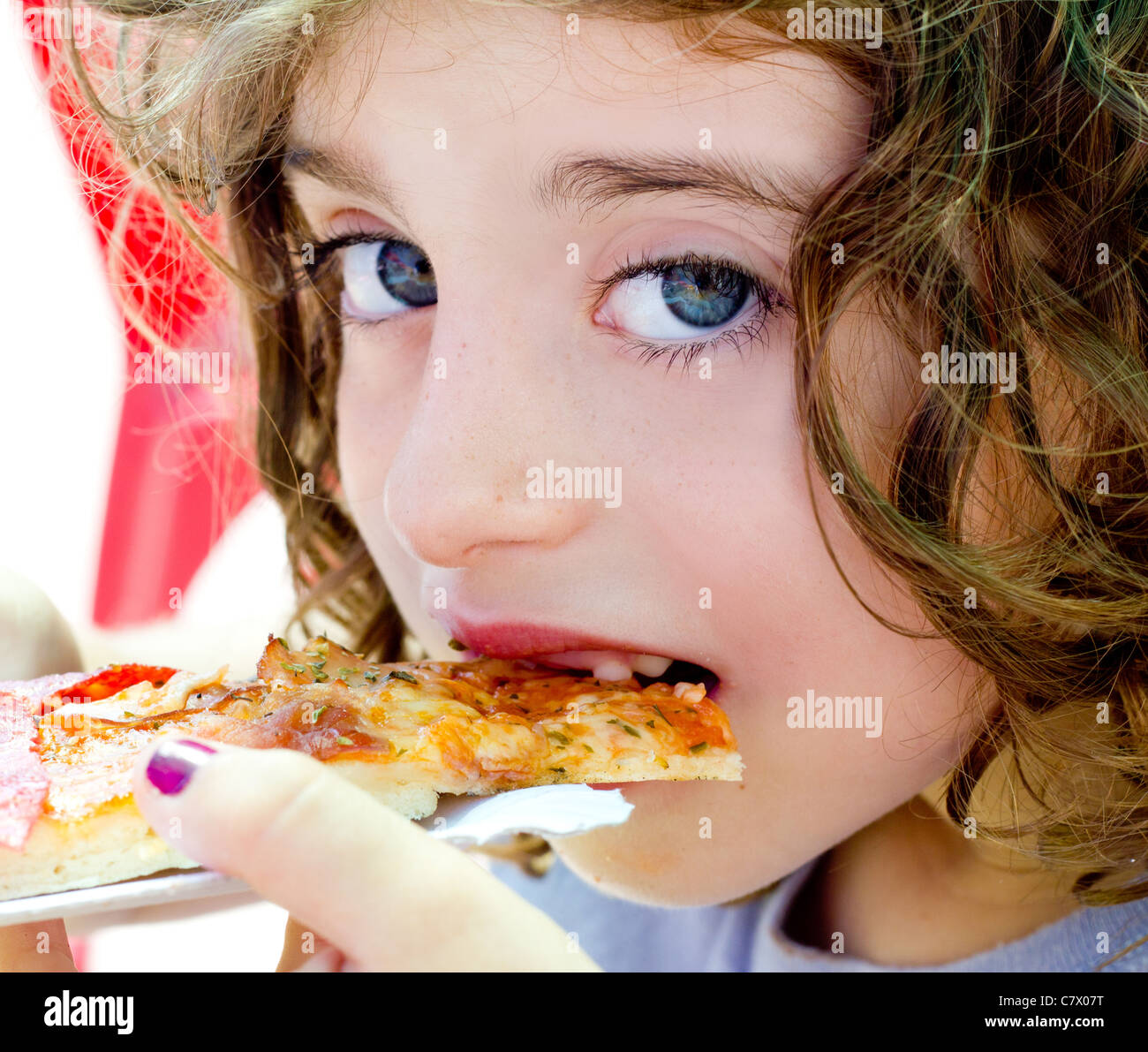blue eyes child girl eating pizza slice hungry Stock Photo - Alamy