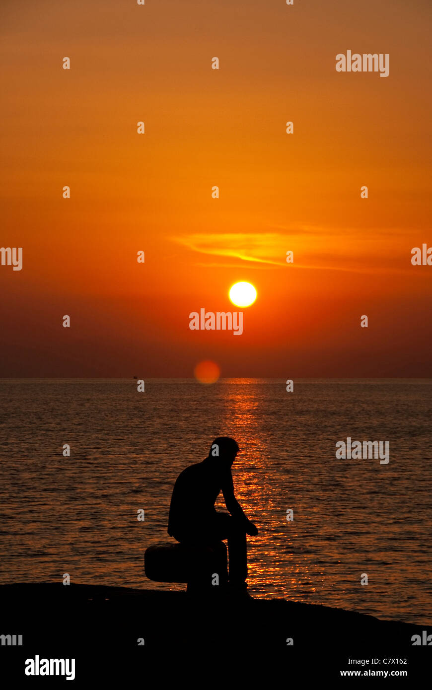 Observer in deep thought silhouetted by the falling sun Stock Photo - Alamy