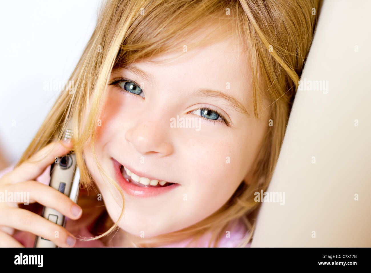 Blond child girl talking mobile telephone smiling happy Stock Photo - Alamy
