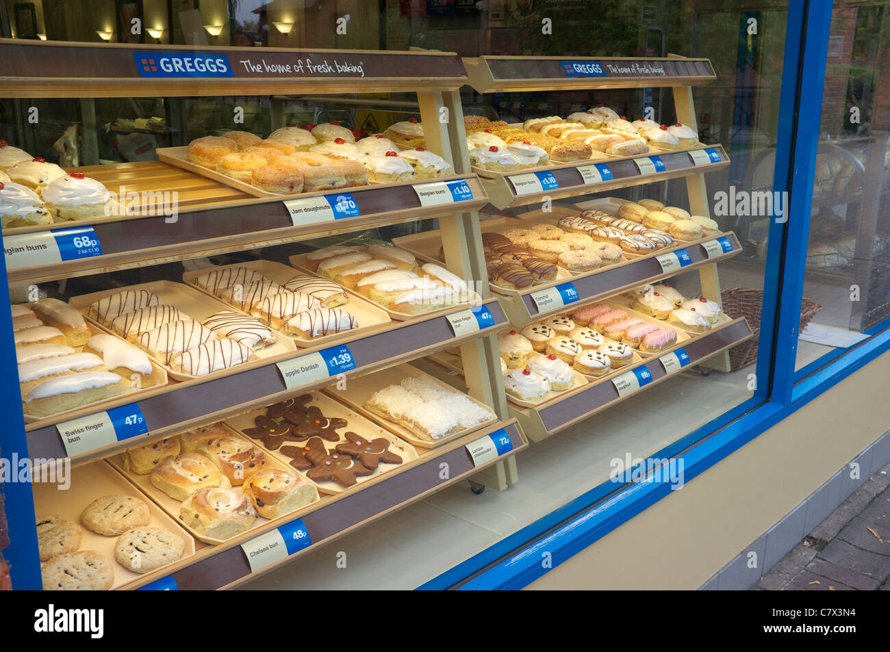 Cakes for sale in UK bakers shop window Stock Photo - Alamy