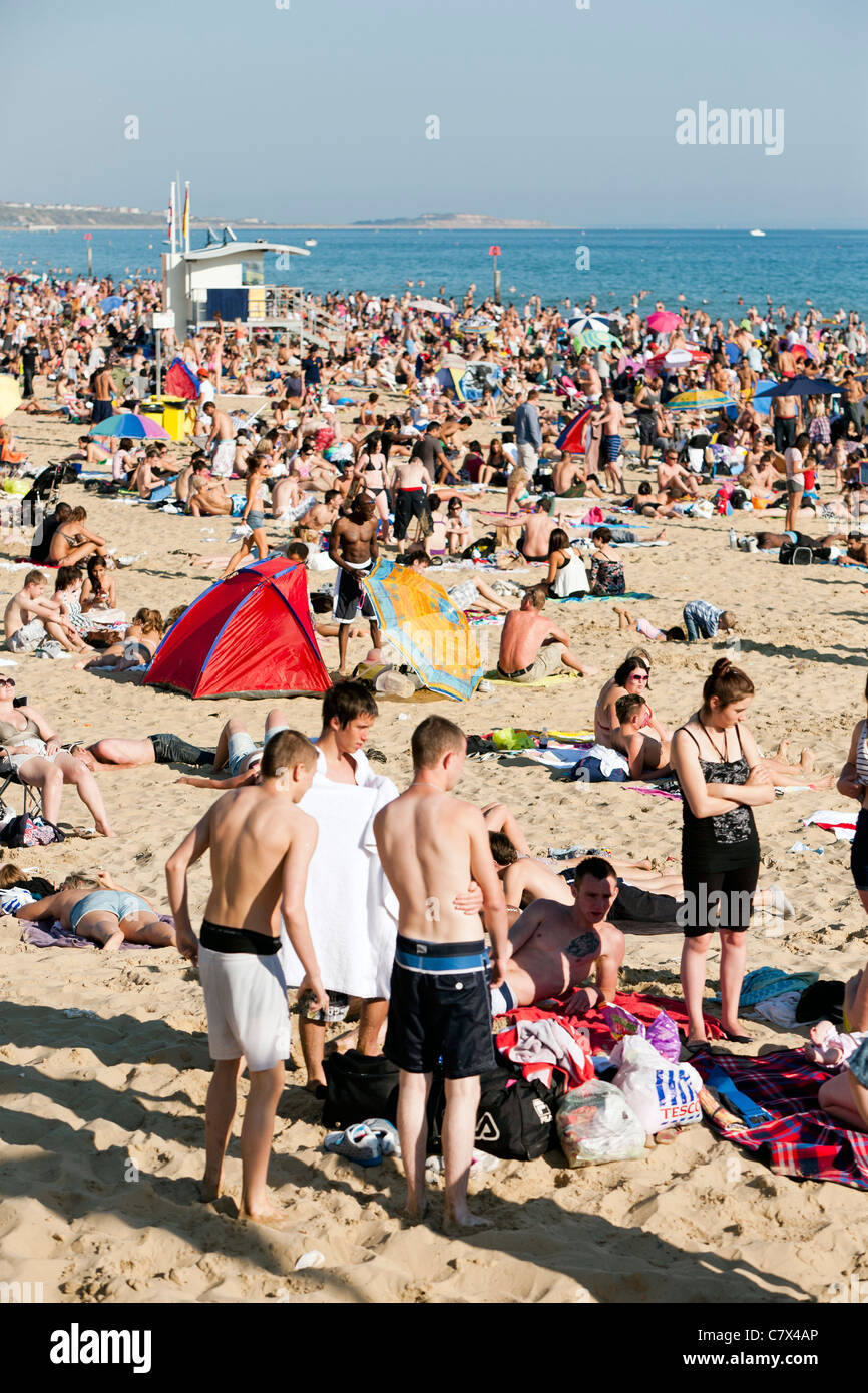 Vast numbers of people cover Bournemouth beach, as far as the eye can ...
