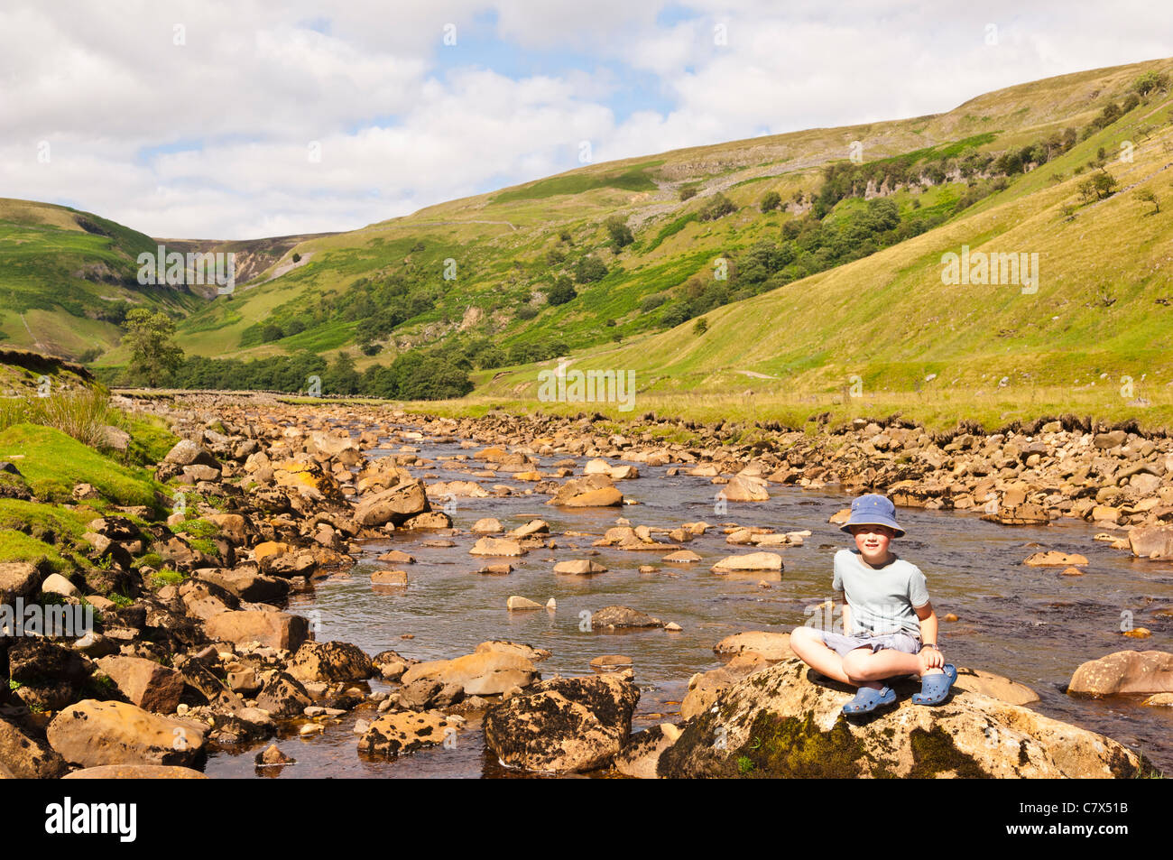 A boy child children playing in the river swale hi-res stock ...