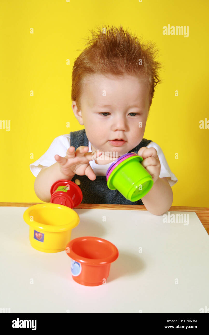 Baby plays with the collection of the small cups Stock Photo - Alamy