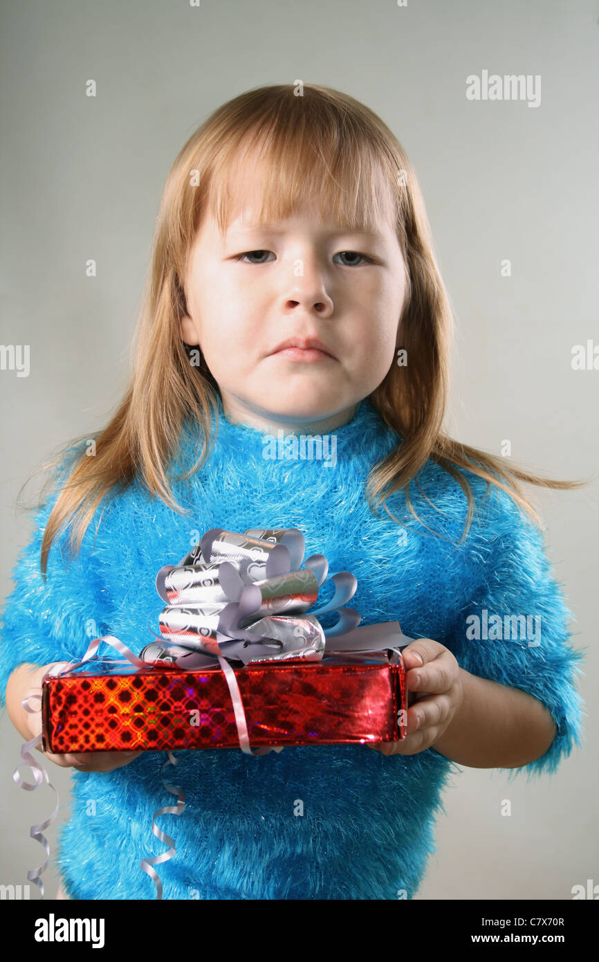 Young girl with unpleasant gift over grey background Stock Photo - Alamy