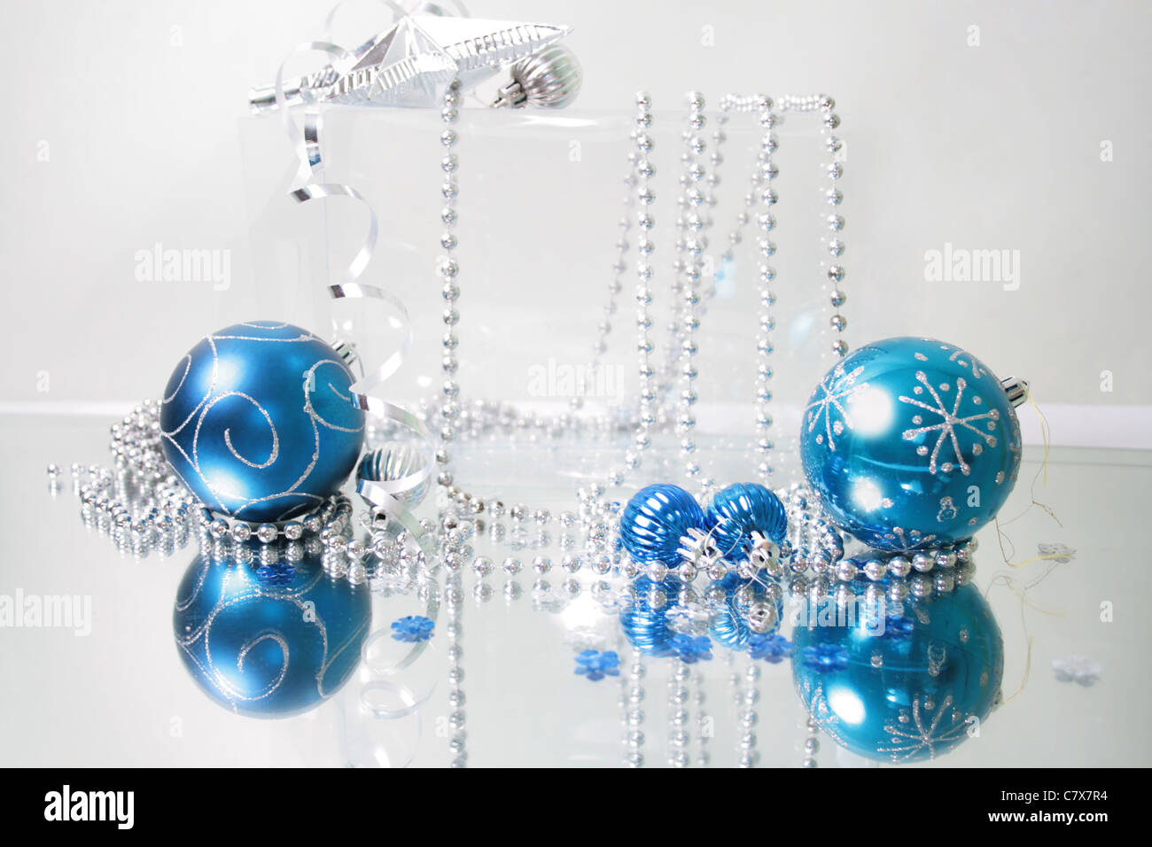 A lovely blue baubles on a mirror surface with ribbons and beads Stock ...
