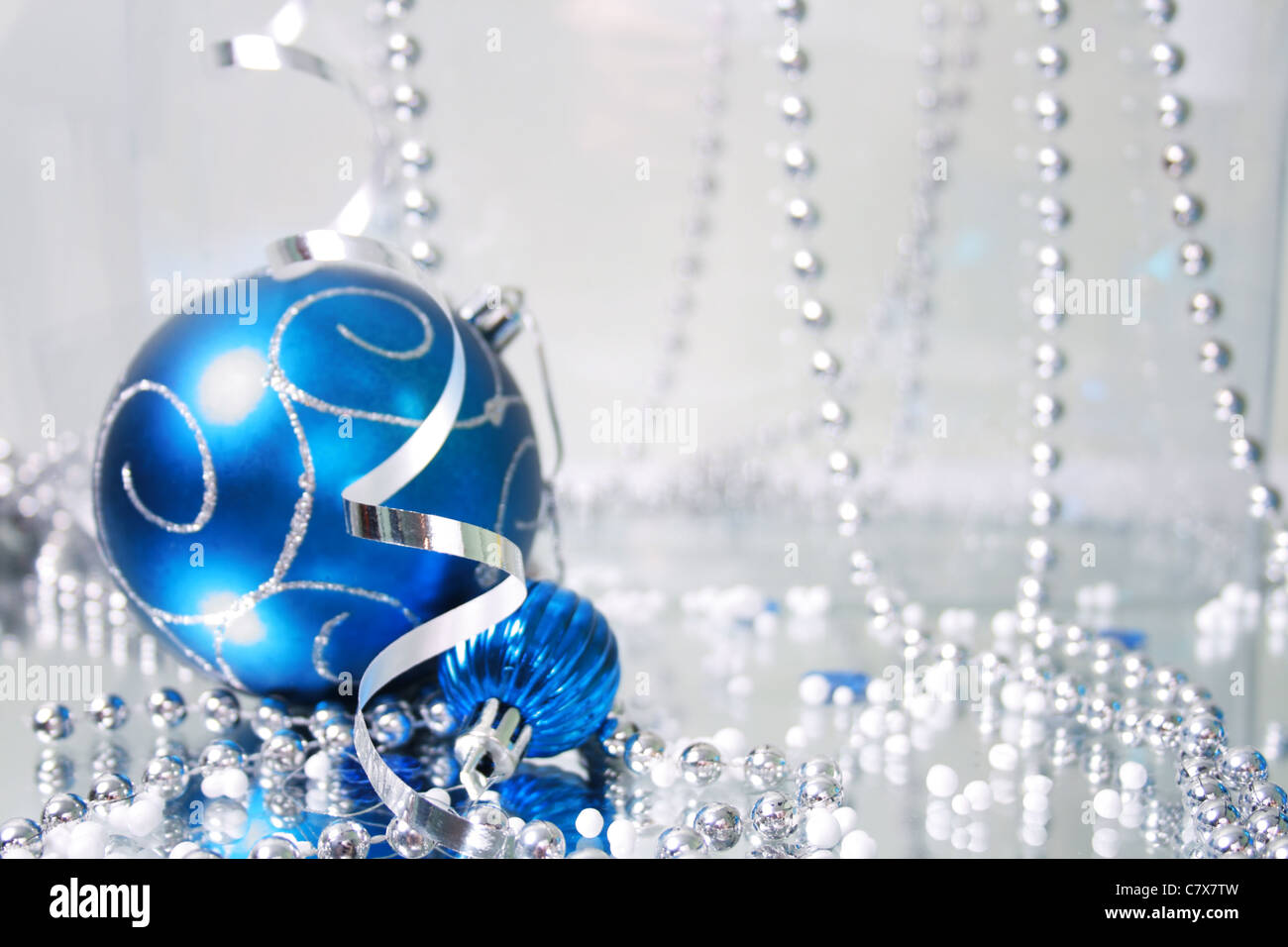 A lovely blue baubles on a mirror surface with ribbons and beads Stock ...