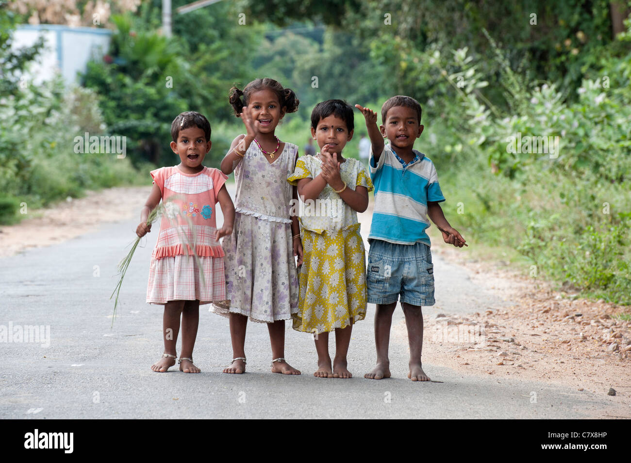 Happy young rural Indian village children standing on a road laughing ...