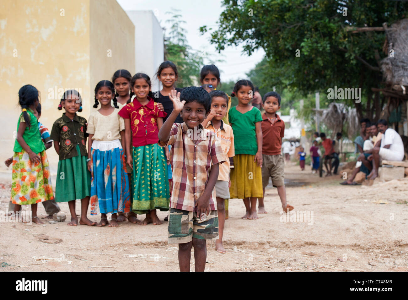 Happy young rural Indian village boy laughing waving in front of a ...