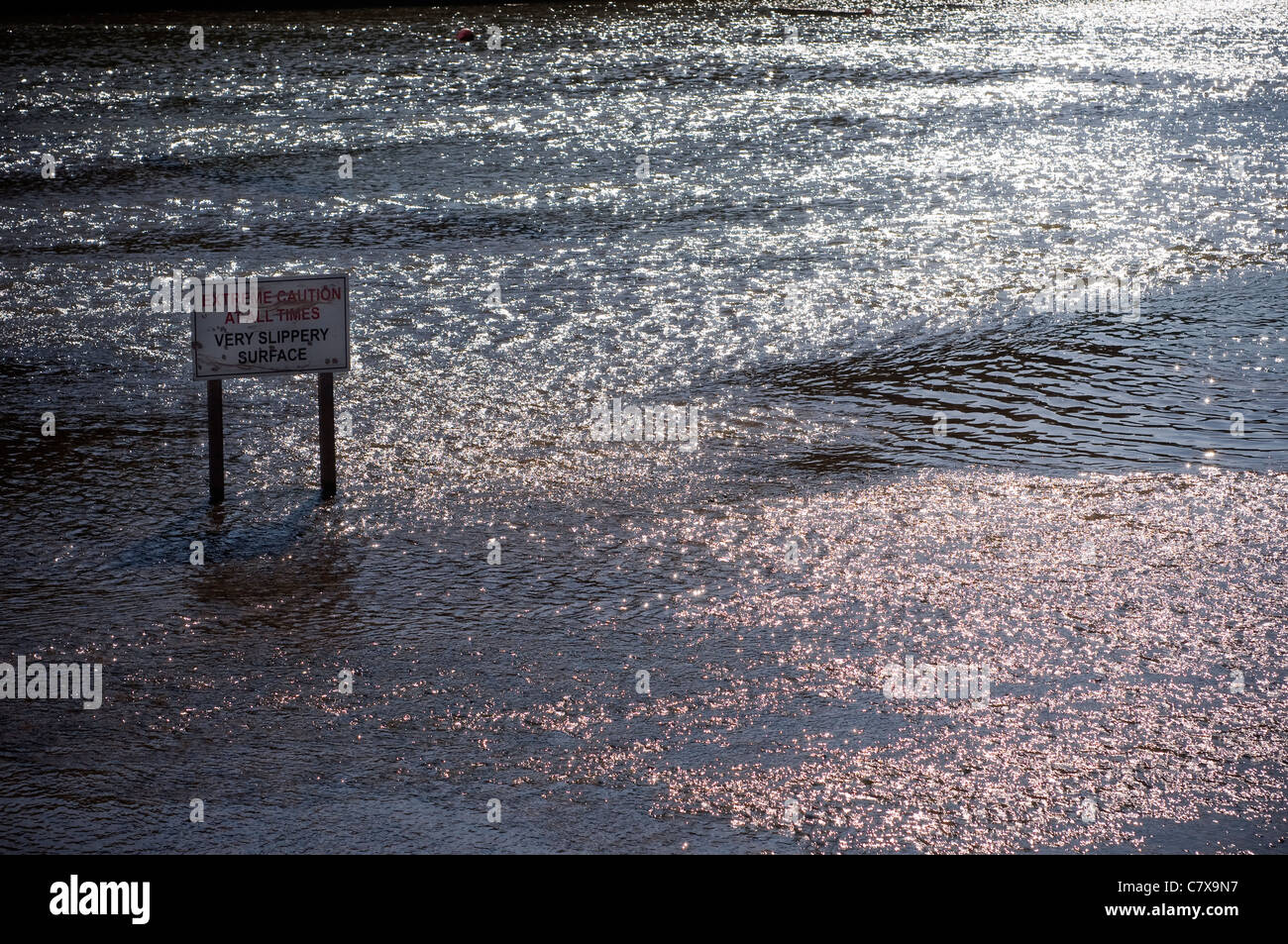 slippery surface sign in water Stock Photo - Alamy