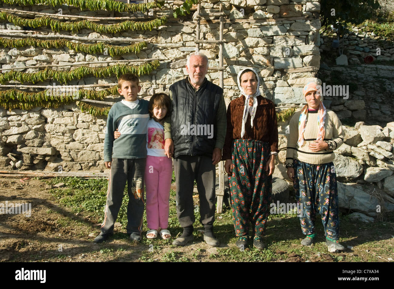 A muslim rural family standing in front of their house, Southern ...