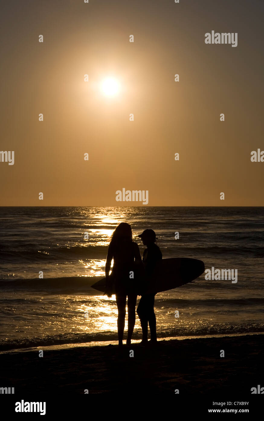 Surfer couple chatting on seashore against sunset in Laguna Beach - CA ...