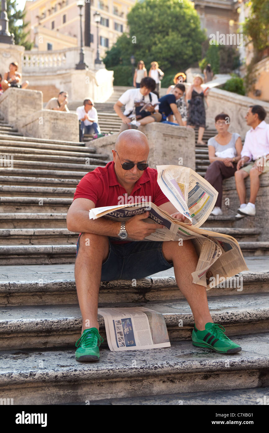 Man reading newspaper sitting on the "spanish Steps" the Trinità de ...