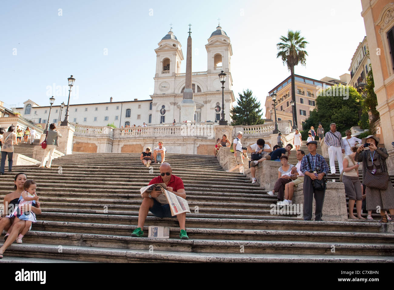 Man reading newspaper sitting on the "Spanish Steps" the Trinità de ...