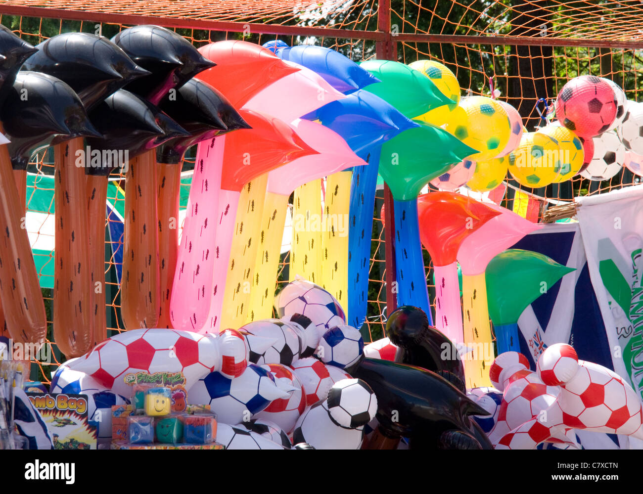 A selection of inflatable hammers and balls on a stall at a festival ...
