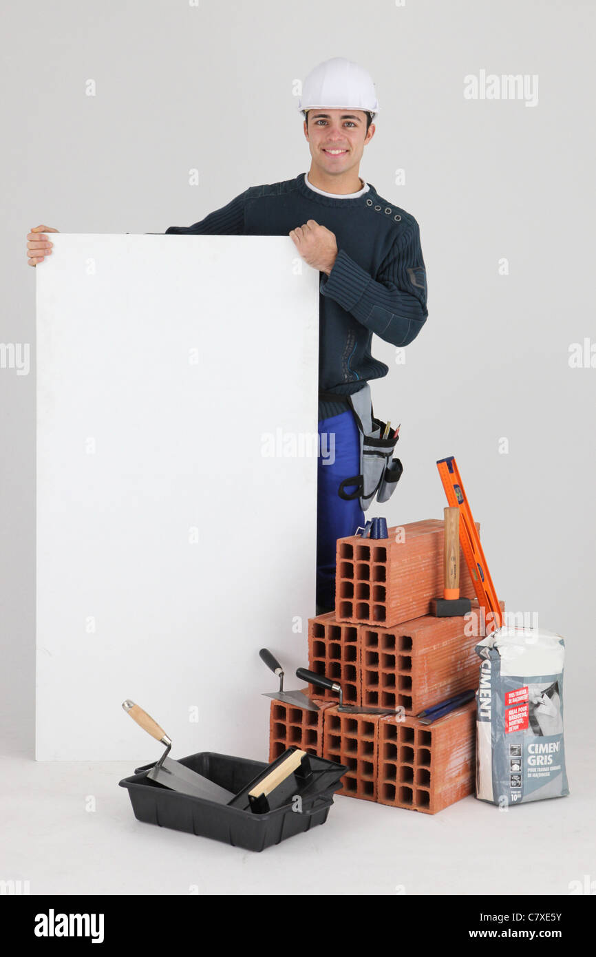 Bricklayer with a blank board Stock Photo - Alamy