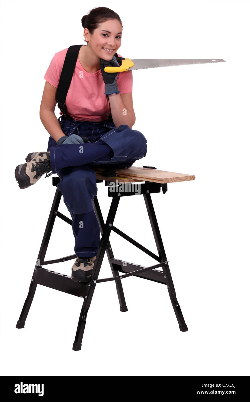 Woman work on workbench holding saw Stock Photo - Alamy