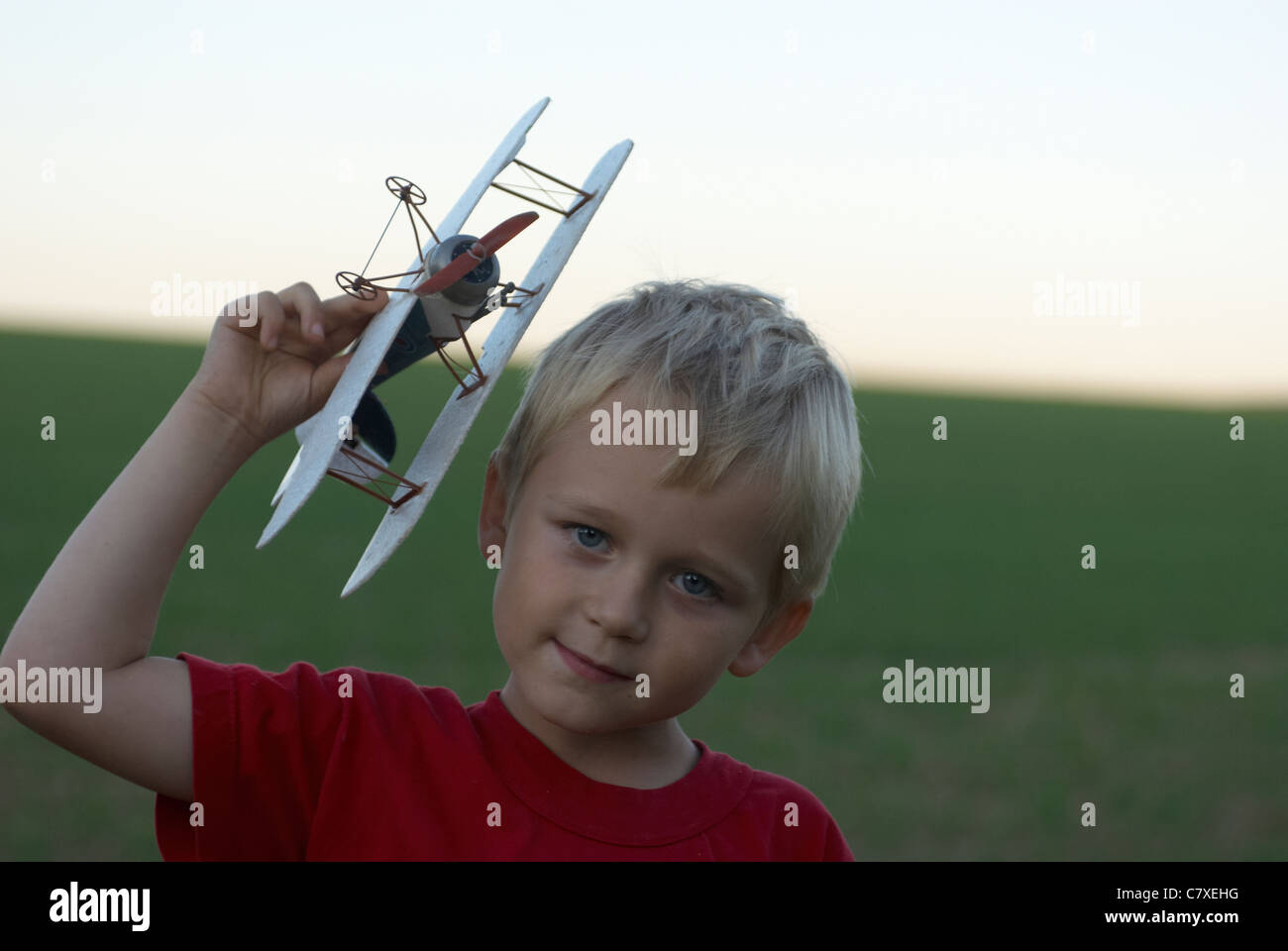 Young child blond boy flying a remote controlled model of plane Sopwith ...