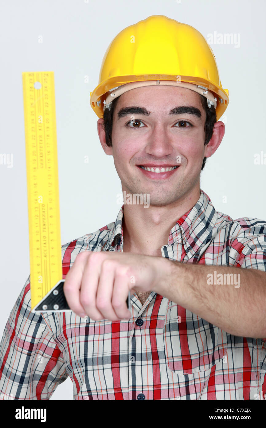 Construction worker holding a try square Stock Photo - Alamy