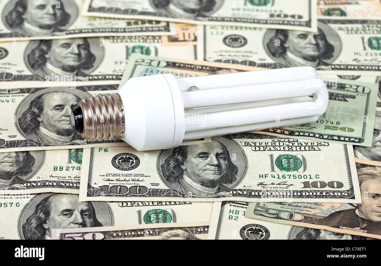 Energy saving light bulb on money background Stock Photo - Alamy