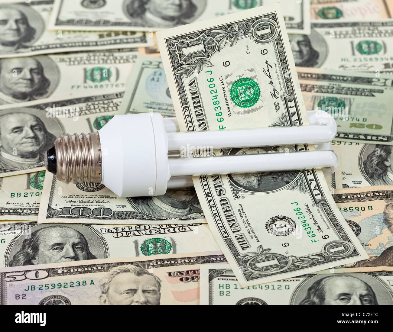 Energy saving light bulb on money background Stock Photo - Alamy