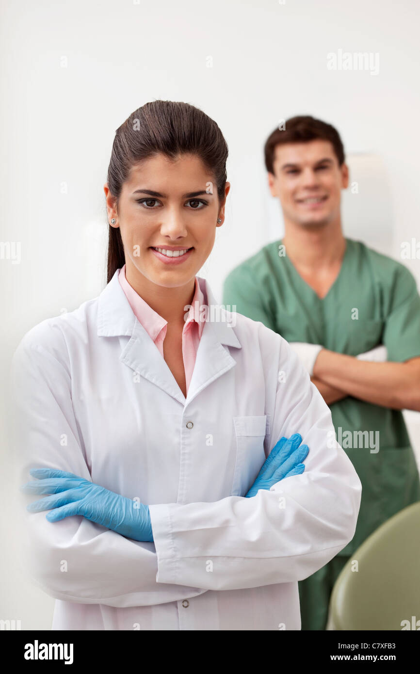 Portrait of pretty female dentist arms crossed with colleague standing ...