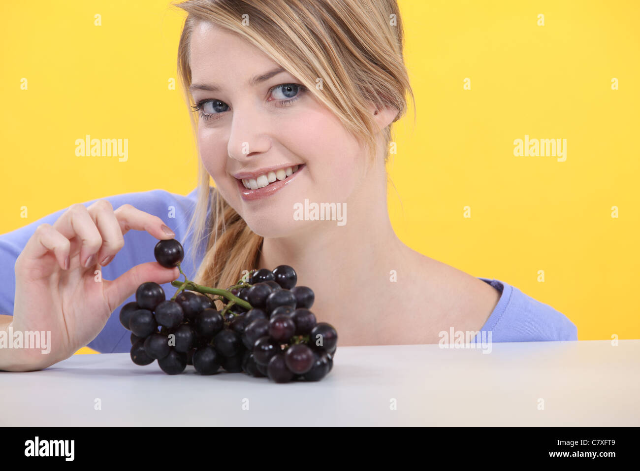 blonde woman showing grapes Stock Photo - Alamy