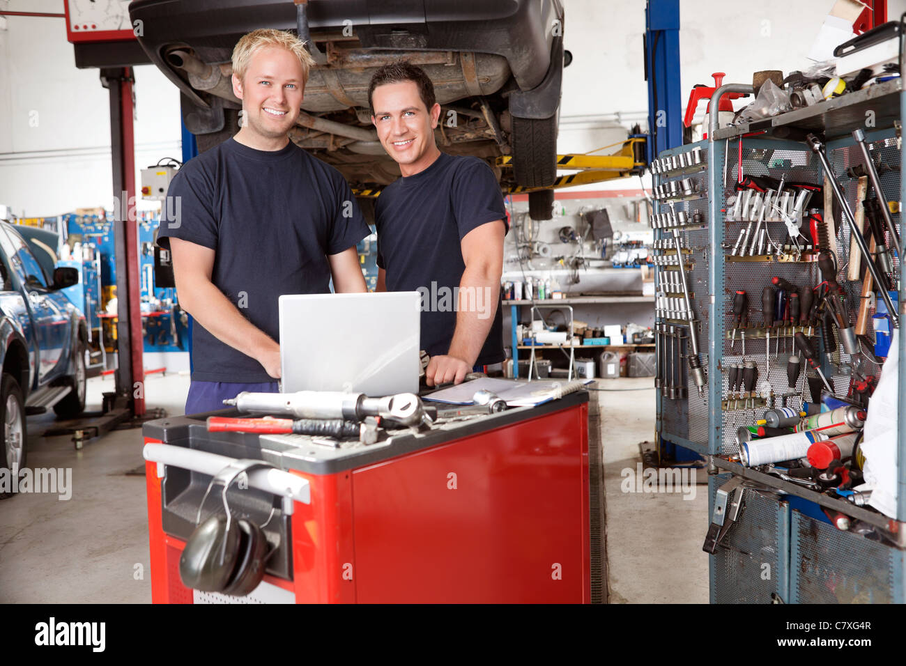 Portrait of mechanics with laptop in auto repair shop Stock Photo - Alamy