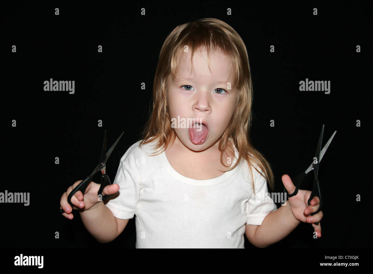 Little girl with scissors. Black background Stock Photo - Alamy