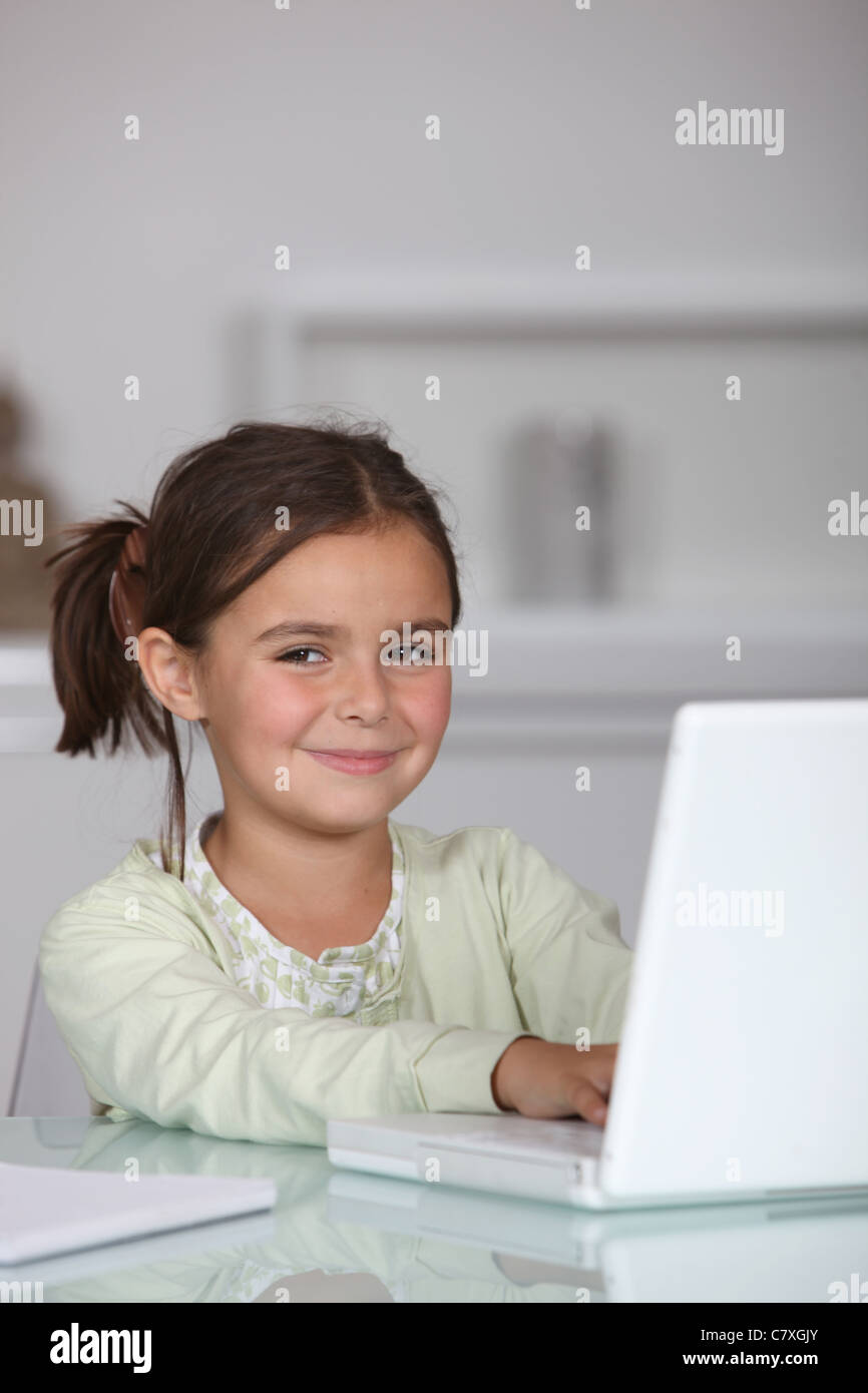 Little girl sat with laptop computer Stock Photo - Alamy