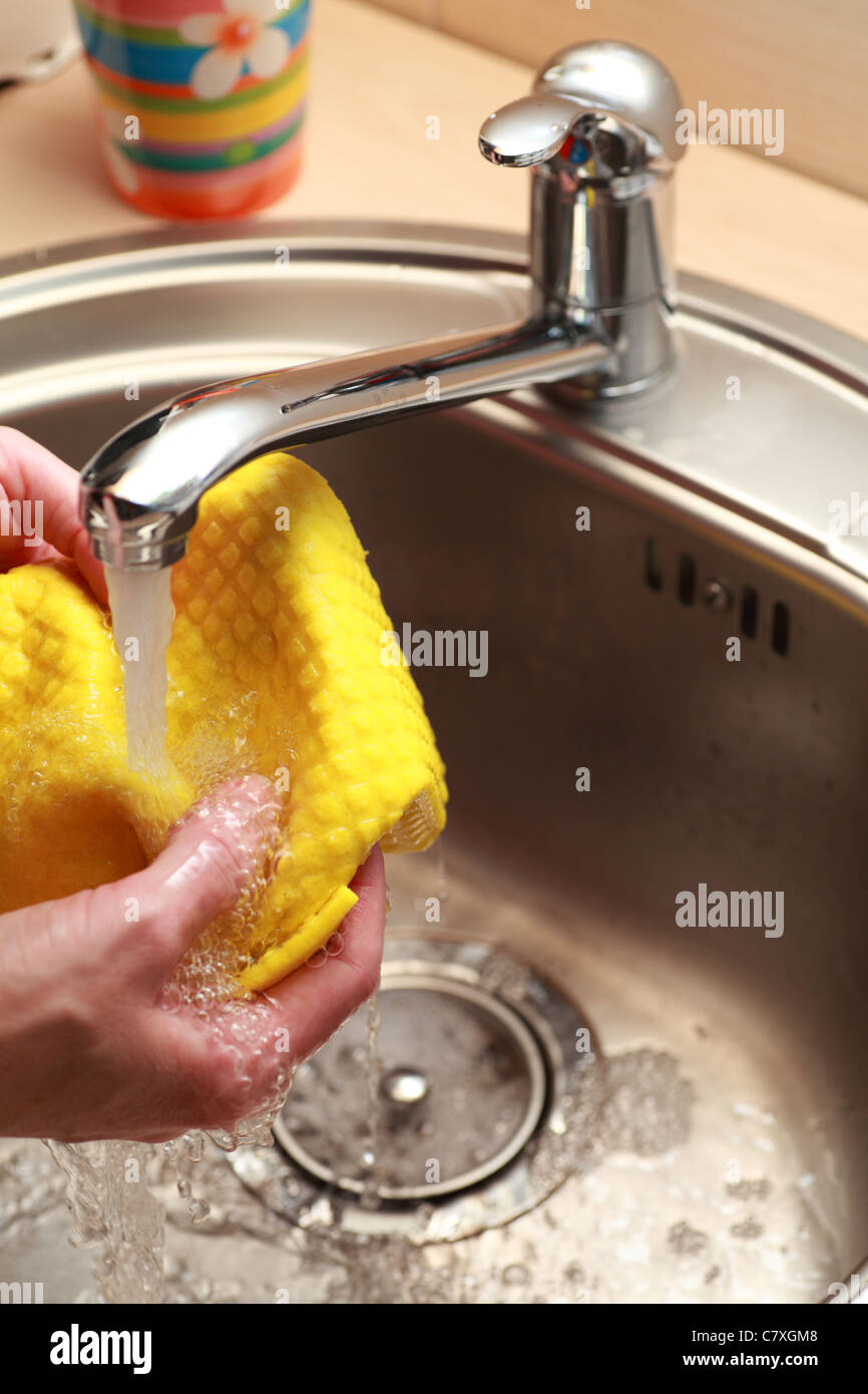 yellow cloth and hands under running water Stock Photo - Alamy