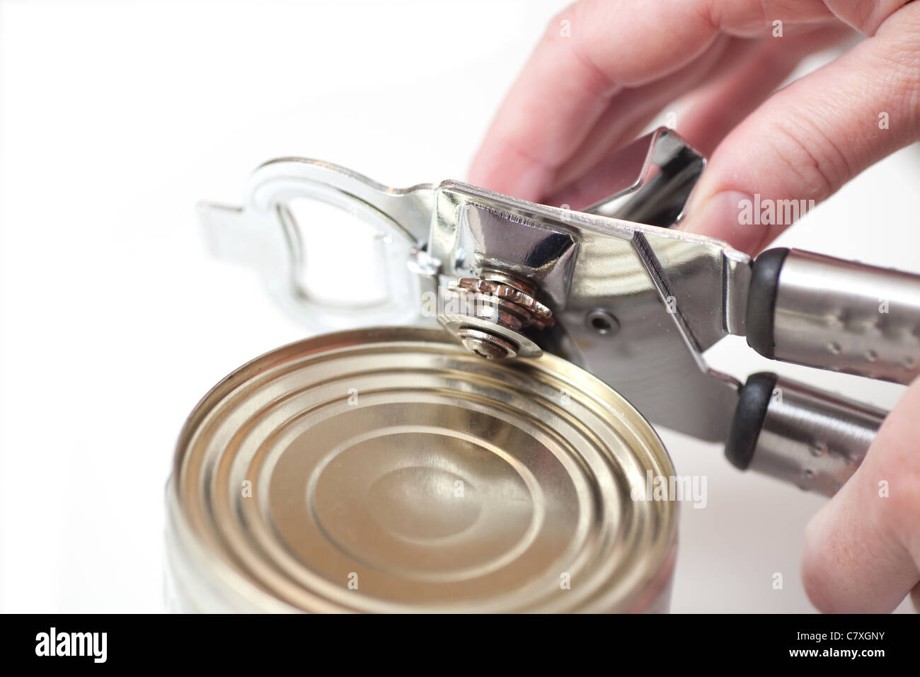 hand Tin opener opening a can of food isolated on white Stock Photo - Alamy