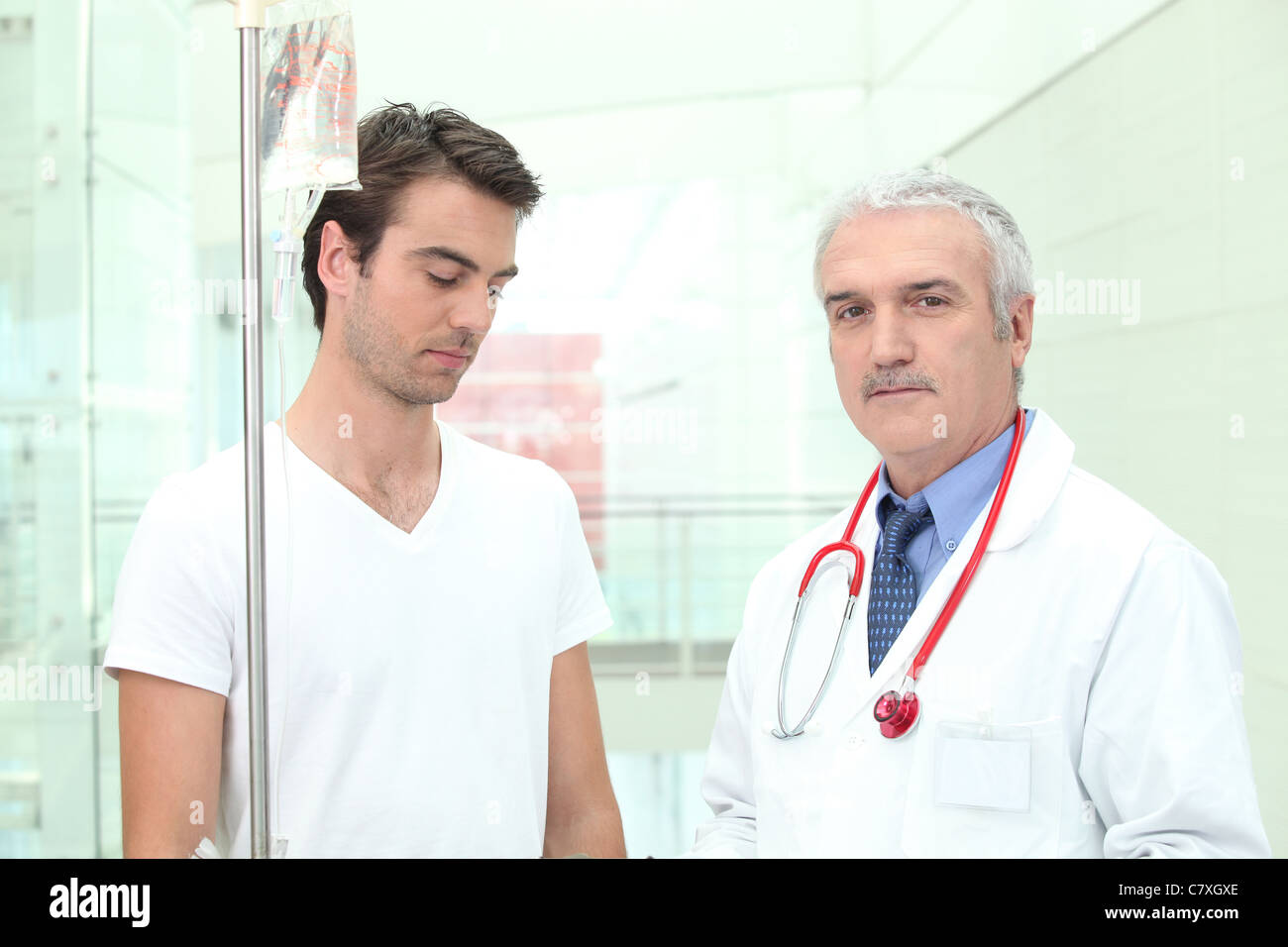 Doctor standing with a patient and his intravenous drip Stock Photo - Alamy