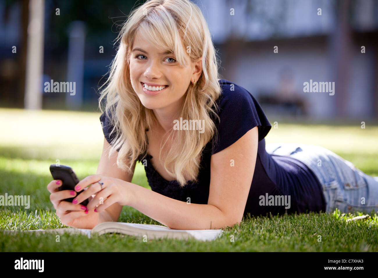 Happy university student sending a text message Stock Photo - Alamy